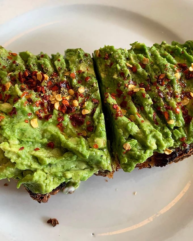 Avocado toast with red pepper flakes—California's contribution to breakfast culture, elevated to an art form worth every penny.