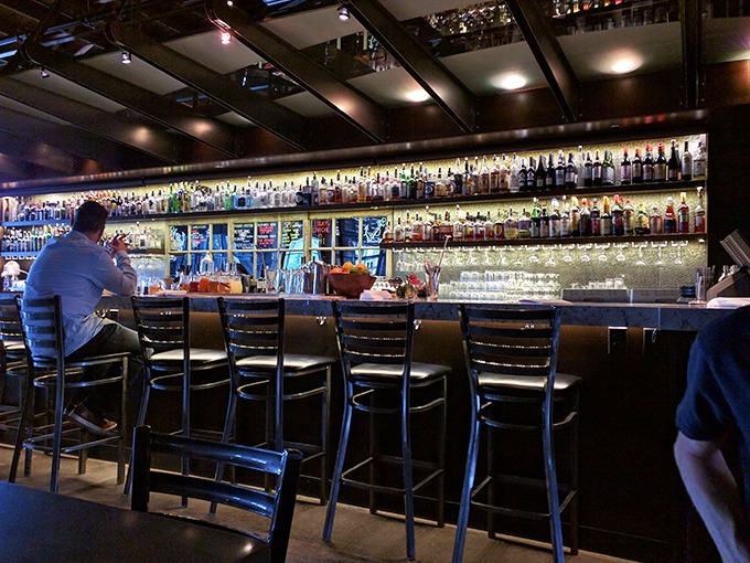 A bar stocked so thoroughly it looks like the alcohol version of Noah's Ark—two of everything, ready to survive any cocktail request.