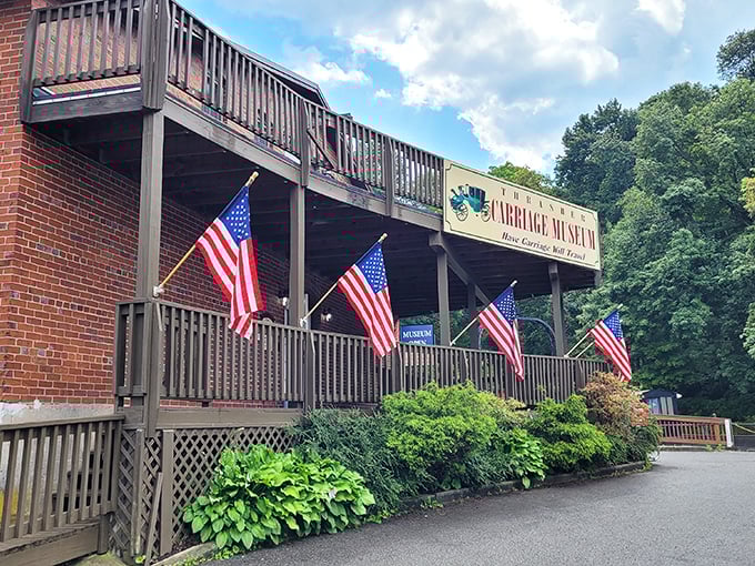 The Carriage Museum stands proudly decorated with American flags, celebrating transportation history before gas prices became dinner conversation.