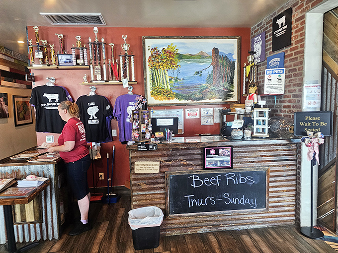 The trophy shelf tells stories of barbecue battles won, while the chalkboard announces when those coveted beef ribs make their weekly appearance—mark your calendars accordingly.