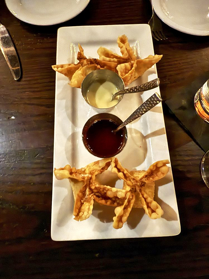These aren't your average crab rangoon—crispy pockets of joy served with dipping sauces standing by for flavor enhancement duty.