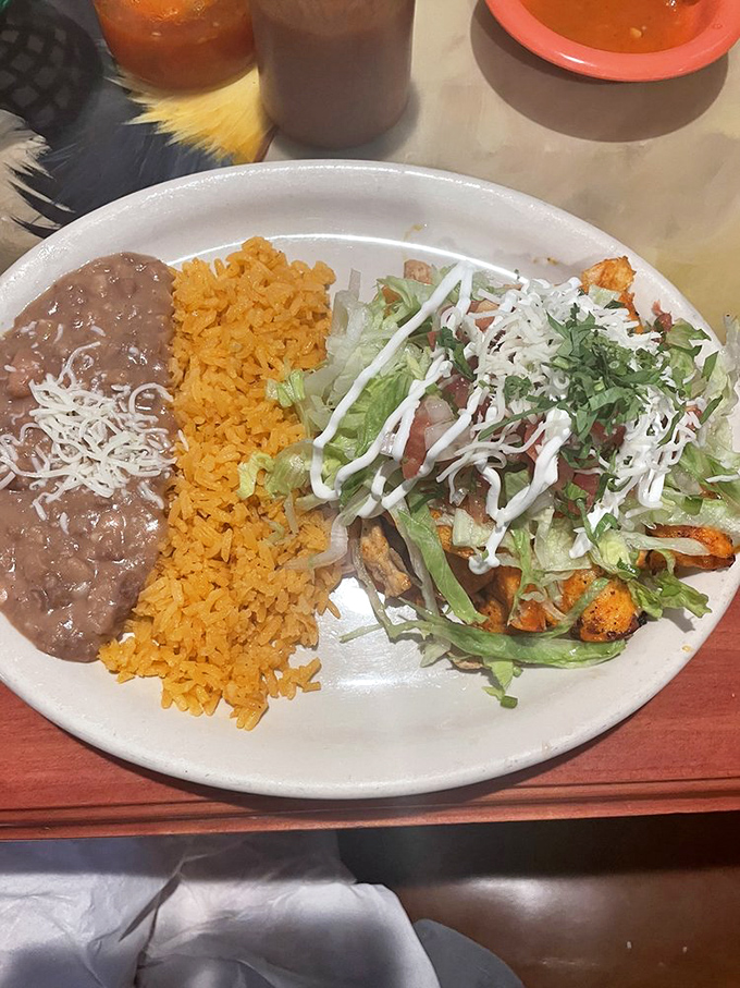 The holy trinity of Mexican restaurant perfection: seasoned rice, slow-simmered beans, and protein cooked by someone who clearly cares.