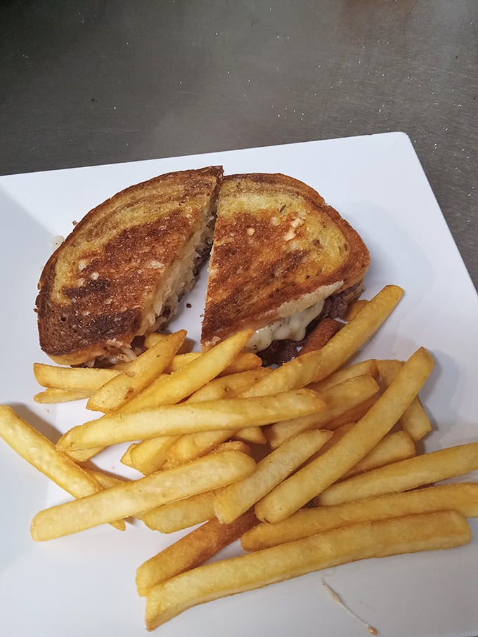 The Reuben sandwich—where corned beef meets sauerkraut in perfect harmony. Those golden fries are just showing off at this point.