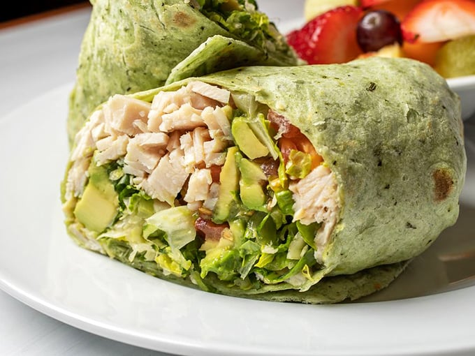 Fresh ingredients wrapped in a vibrant green tortilla—this isn't just lunch, it's portable happiness with avocado and turkey.