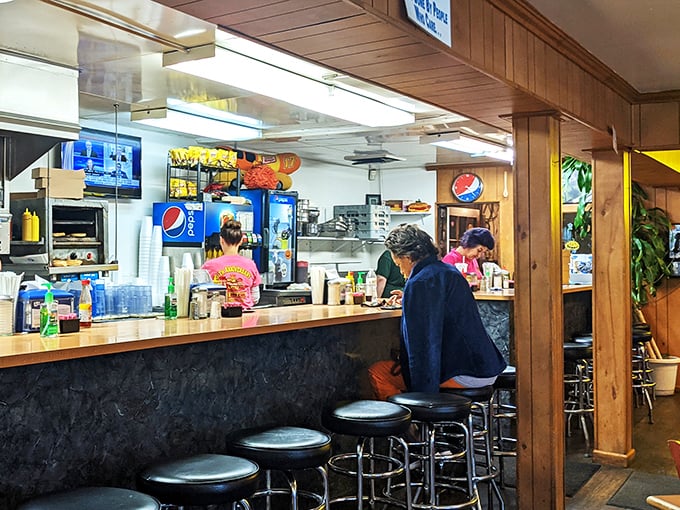 The counter where magic happens—where orders are called out in a language perfected over years, and where solo diners find community in shared appreciation of simplicity.