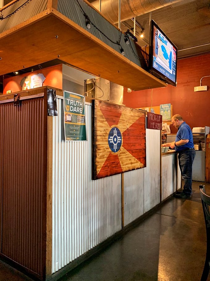 The Wichita flag proudly displayed at the counter—a reminder that regional barbecue isn't just food, it's cultural heritage with sauce.