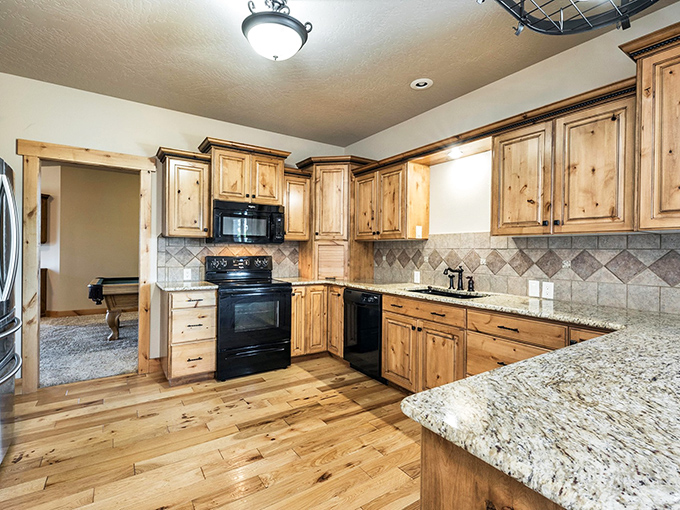 This kitchen blends rustic warmth with modern convenience, featuring knotty pine cabinets and granite countertops that would satisfy even the most demanding royal chef.