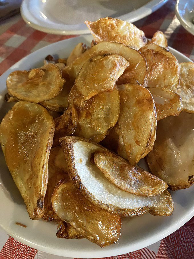 These aren't your sad bagged chips—these house-made potato crisps shatter with each bite, leaving you wondering why you'd ever settle for less.