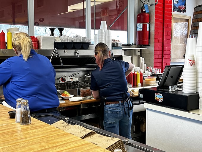 Behind the counter, skilled hands work with the confidence that only comes from making thousands of the same perfect burger, day after day.