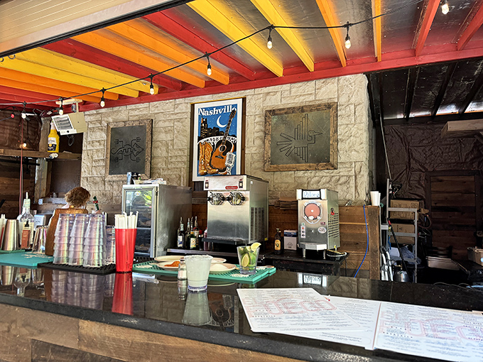 The bar area combines rustic stone, colorful ceiling beams, and Nashville charm—a perfect backdrop for margarita-fueled conversations about life.