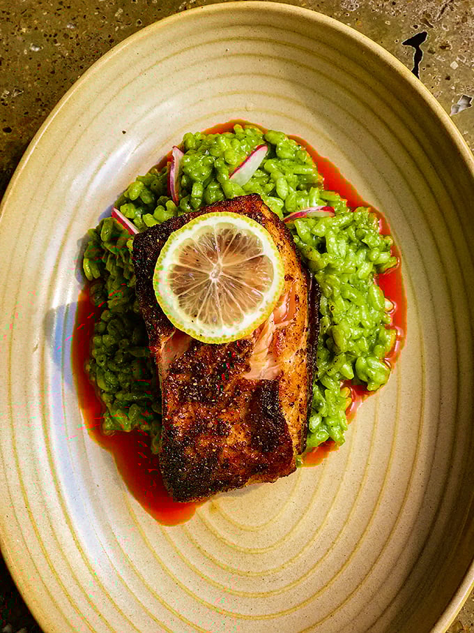 Perfectly seared salmon atop vibrant green rice—a dish that proves Mexican cuisine extends far beyond the taco stand.