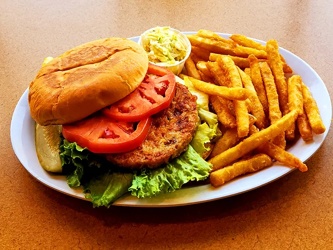 This isn't just a burger—it's architecture with lettuce. The golden fries standing at attention like they know they're part of something important.