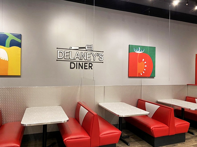 Red booths against white walls with playful food art create that perfect diner atmosphere – comfortable without being kitschy.