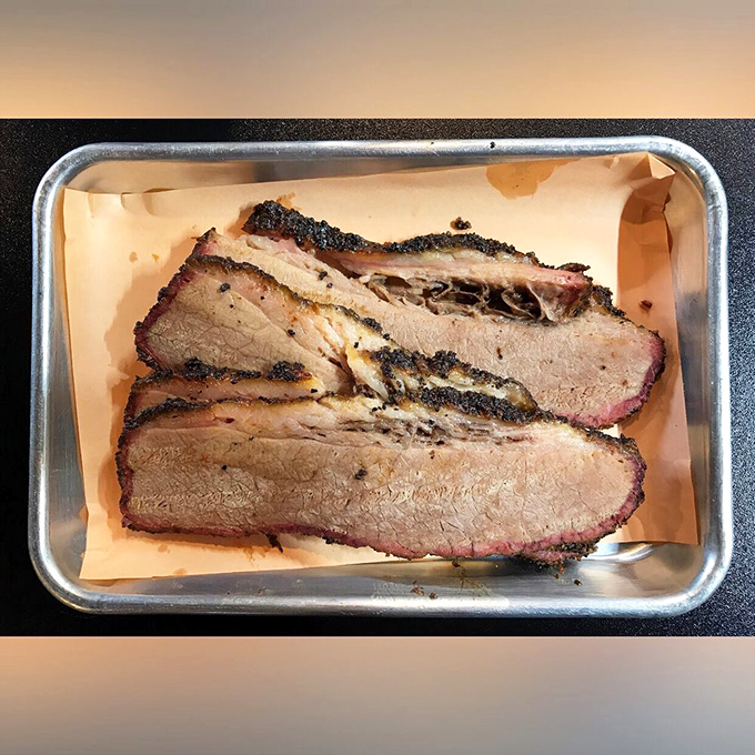 Brisket sliced thick enough to show off that perfect pink smoke ring. This isn't just meat—it's a time capsule of patience and wood smoke.