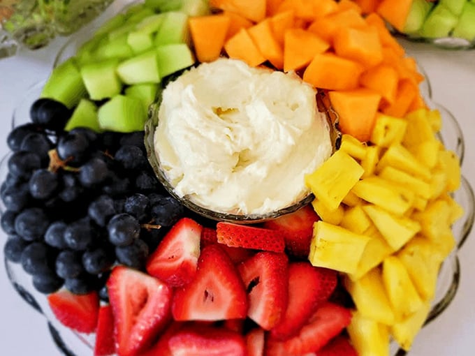 A fruit platter that celebrates nature's candy, arranged around creamy dip. This isn't just dessert; it's how adults justify eating sweets for a snack.