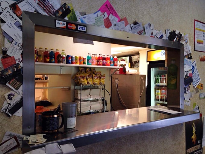 Business cards and credit card logos frame this window like a shrine—the humble gateway to barbecue enlightenment.