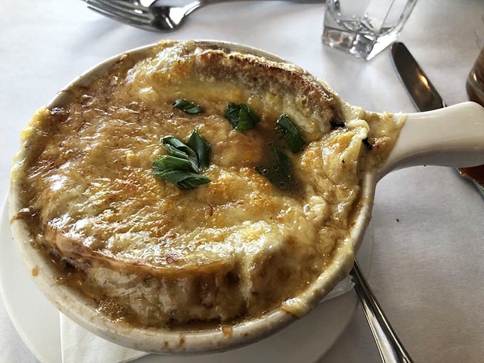 French onion soup that's practically wearing a cheese toupee—a bubbling cauldron of sweet onions and savory broth beneath a golden crown.