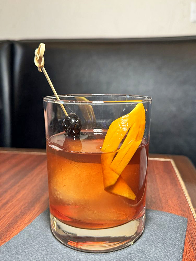 A perfectly crafted cocktail with an orange twist that's dressed for success. This drink isn't just served – it's presented.