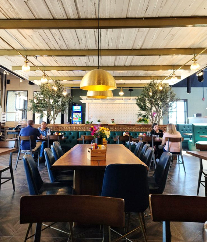 A dining room where breakfast isn't just served but celebrated – under golden pendant lights that make everyone look like they got enough sleep.