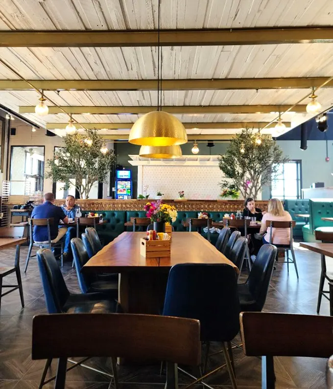 A dining room where breakfast isn't just served but celebrated – under golden pendant lights that make everyone look like they got enough sleep.