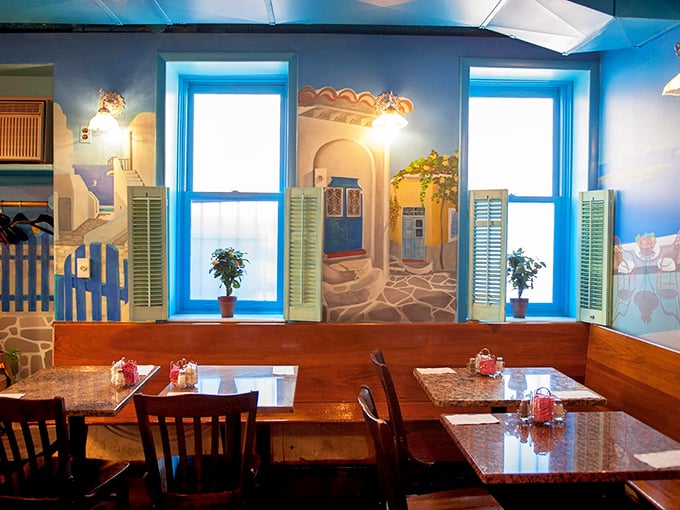 Dining beneath a mural of Greek coastal scenes – the closest thing to eating in Santorini without needing your passport or dealing with airport security.