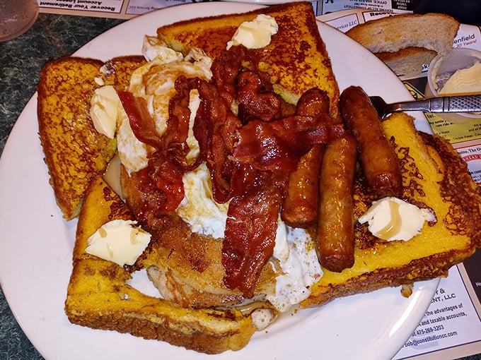 French toast living its best life with bacon and sausage. Breakfast doesn't get more gloriously indulgent than this butter-kissed masterpiece.