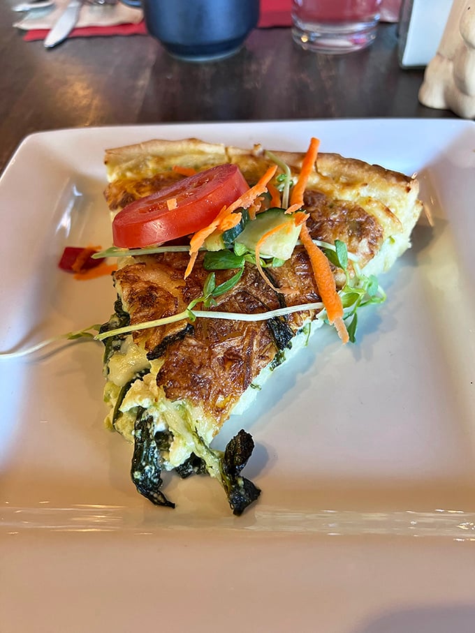 This quiche slice is the Goldilocks of breakfast—not too heavy, not too light, with vegetables adding color like confetti at a very sophisticated party.