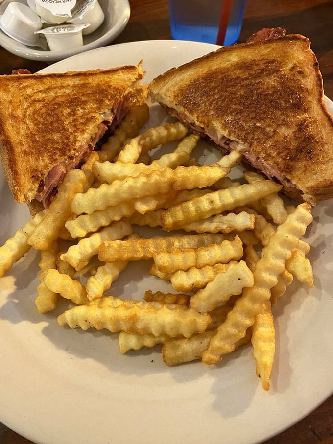 This grilled cheese and ham sandwich with crinkle-cut fries isn't just lunch—it's a time machine back to the best parts of childhood.