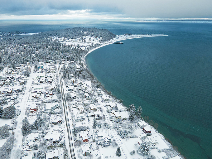 Winter blankets the peninsula in snow, creating a postcard-perfect contrast between the deep blue waters and shoreline dressed in its seasonal white finery.