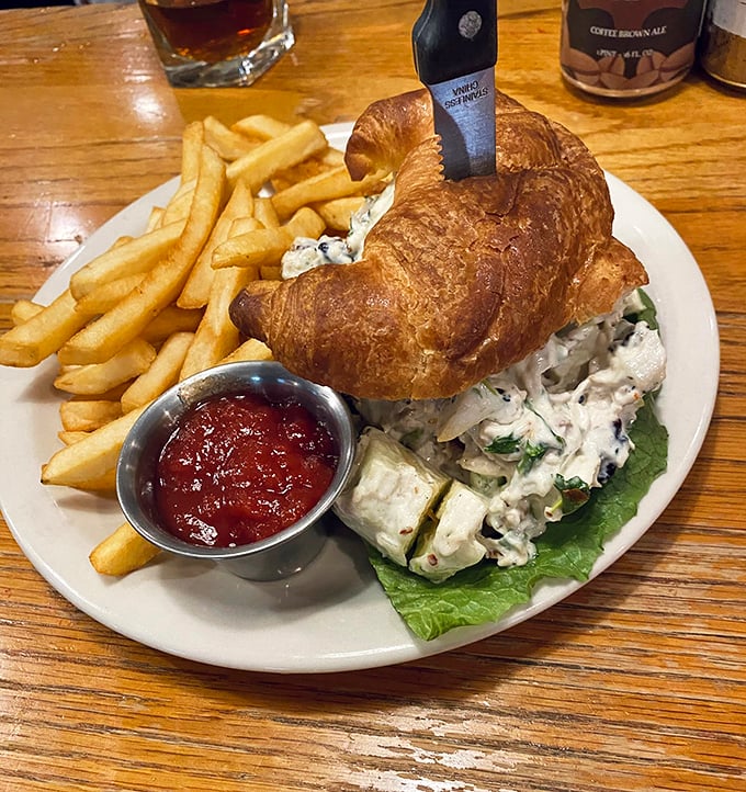 This chicken salad croissant isn't just lunch—it's edible architecture. Flaky, buttery pastry cradles creamy chicken salad with fries standing at attention alongside.