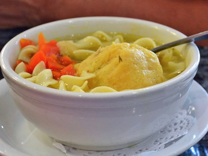 Chicken noodle soup with a matzo ball that doesn't just float—it commands respect in a sea of perfectly cooked noodles.