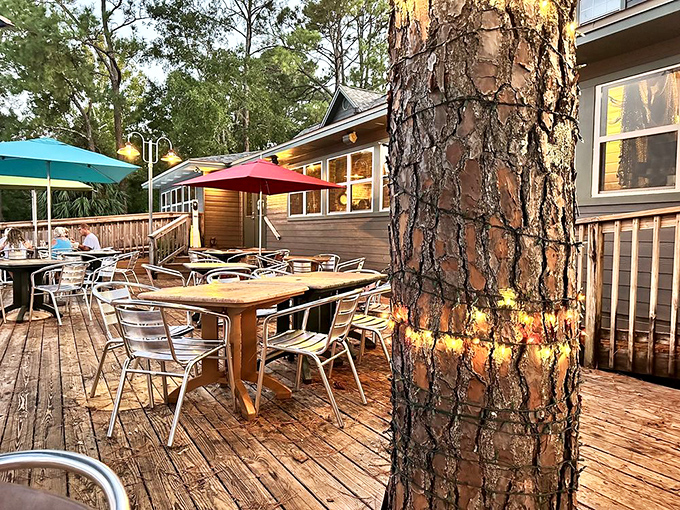 The outdoor deck beckons with shaded tables under colorful umbrellas, where pine trees provide nature's own air conditioning.