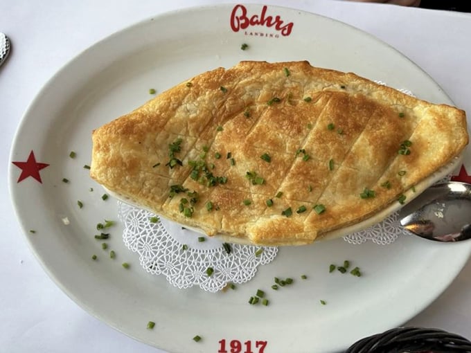 This golden-topped pie isn't just a dish—it's edible architecture, with a flaky roof protecting the treasures of the sea hiding underneath.