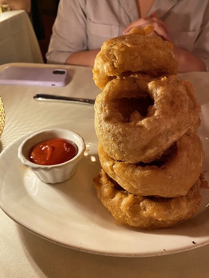 Golden onion rings stacked like delicious Olympic rings—crispy, airy halos that make you wonder why vegetables ever bothered growing any other way.