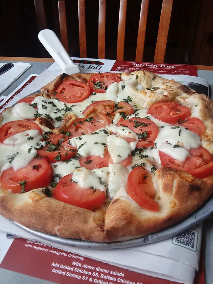 A margherita pizza that celebrates simplicity – fresh tomatoes, basil, and mozzarella proving that less is more when ingredients are quality.