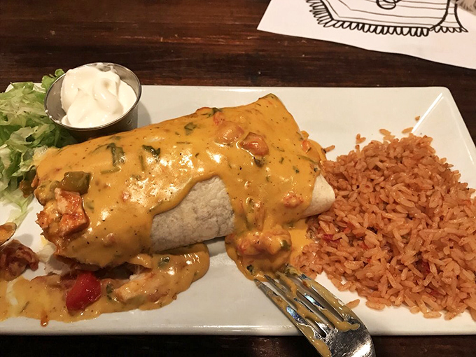 This burrito smothered in cheese sauce isn't just food—it's a warm, melty hug for your taste buds.
