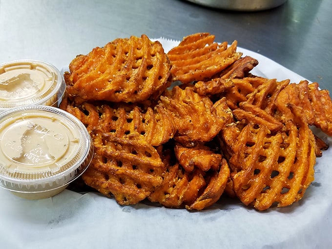 These waffle-cut sweet potato fries aren't just sides—they're main attractions with supporting roles, dressed in spices that would make Broadway jealous.