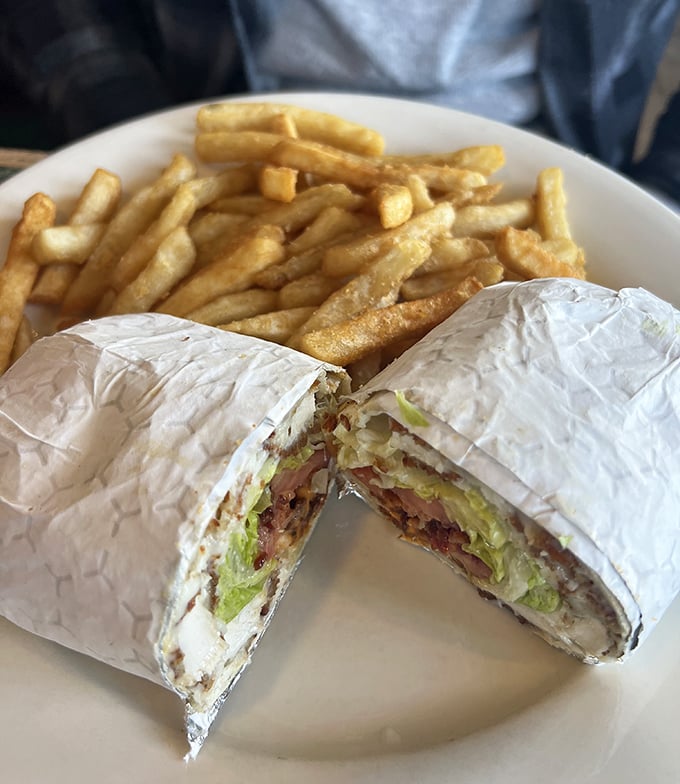 The humble wrap elevated to art form, sliced to reveal its colorful interior secrets, with fries standing by for dipping duty.
