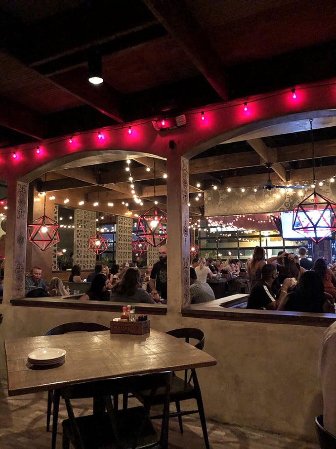 The evening crowd bathes in the warm glow of string lights, creating that perfect atmosphere where food, drinks, and conversation flow freely.