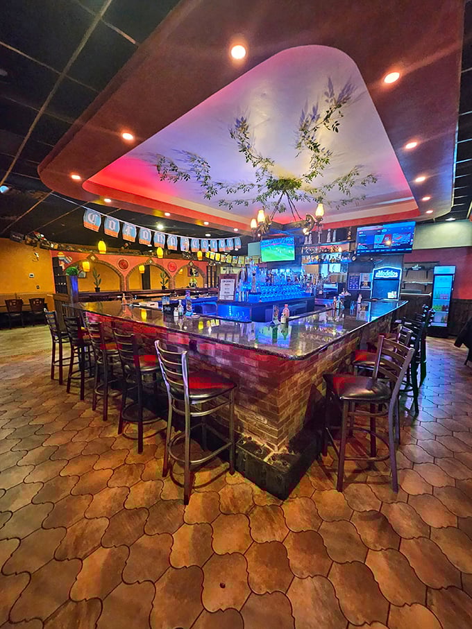 The bar at Fiesta Maya doesn't just serve drinks—it creates community under the gentle glow of colorful lights. This is where stories get told and weekdays get redeemed.