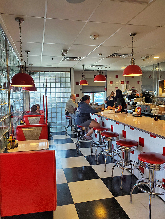 The counter—where solo diners become family and the coffee keeps flowing. Red stools invite you to spin exactly once before the server gives you "the look."