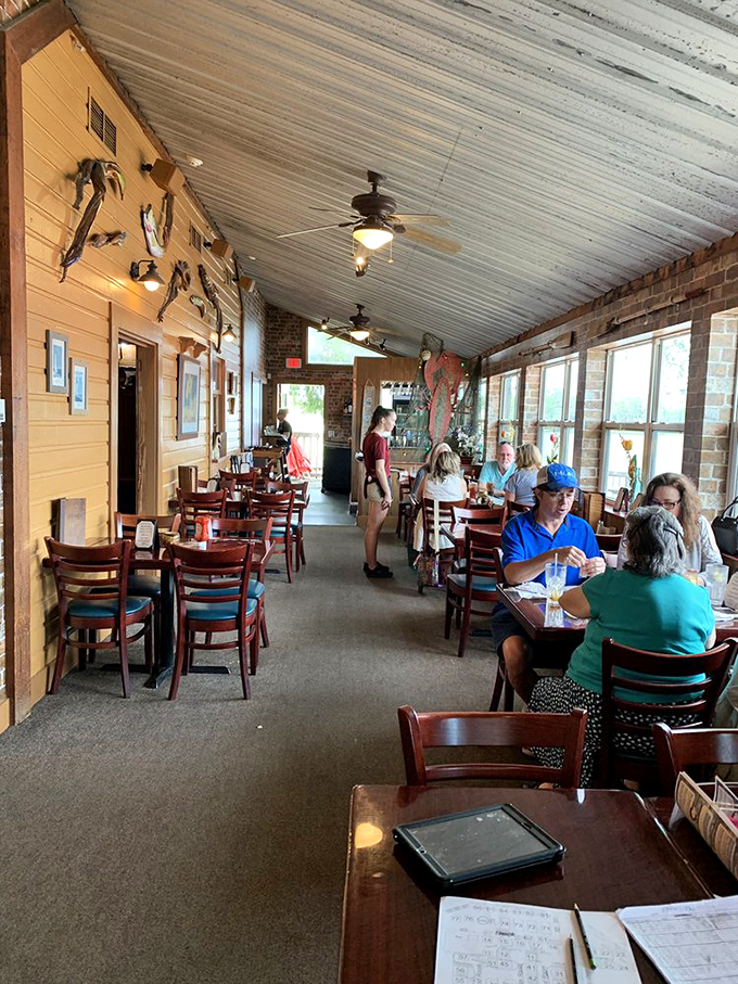 Inside the nautical-themed dining room, patrons enjoy meals beneath fishing memorabilia—a reminder of exactly where today's catch originated.