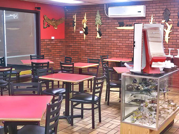 Red tabletops, brick walls, and wooden wildlife mounts—the classic BBQ joint trifecta that signals you're about to eat something memorable.