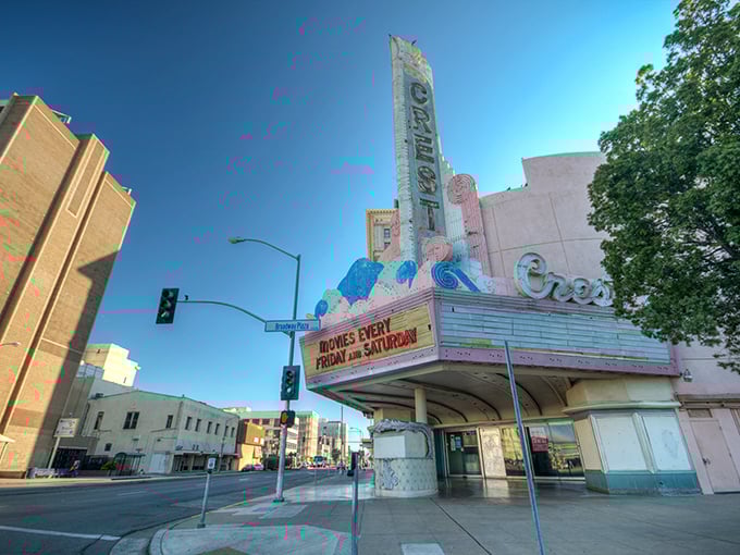 The historic Crest Theatre in Fresno stands like a pastel sentinel, its vintage marquee promising entertainment that won't break your Social Security budget.