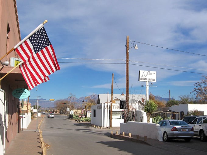 Mesilla's main street, where American flags wave proudly over adobe buildings that have seen more history than your high school textbook.