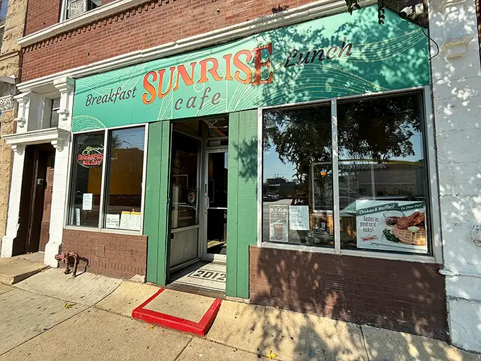 The cheerful green storefront of Sunrise Cafe beckons like an old friend. A breakfast sanctuary where pancake dreams come true!