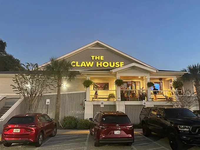 As evening falls, The Claw House glows with promise – those yellow letters practically whisper, "lobster awaits inside."