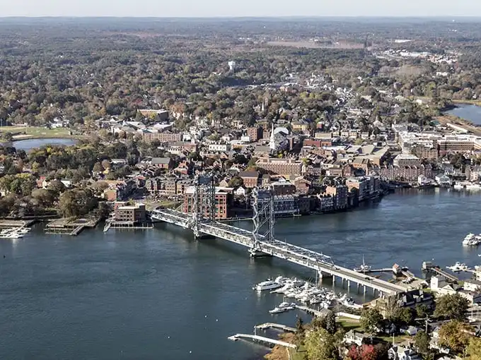 Portsmouth's panoramic personality on full display. The Memorial Bridge connecting Maine to New Hampshire serves as both boundary and welcome mat.