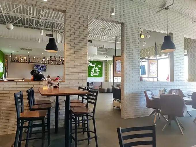 Clean lines, white brick walls, and that neon sign promising "Meet Me at Brunch"—this is where morning meals get their well-deserved glow-up.