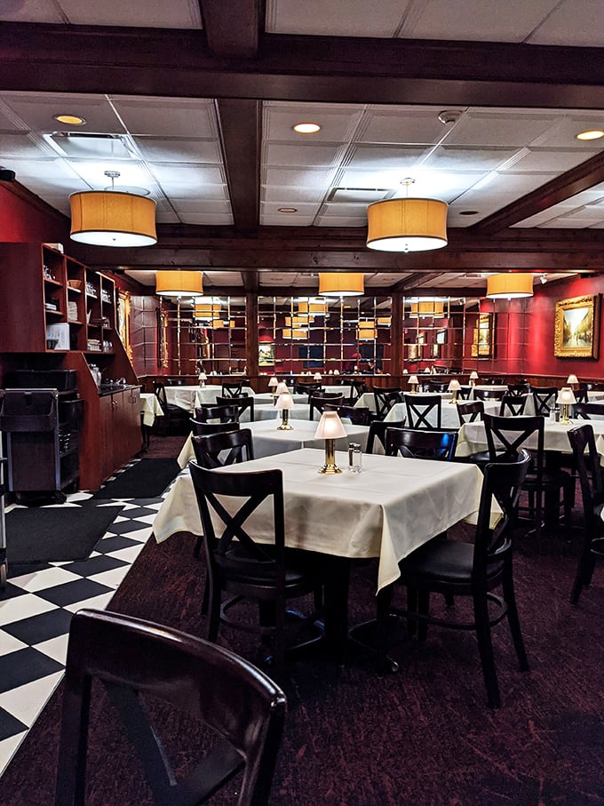 Step into a dining room where red walls, crisp white tablecloths, and checkered floors create the perfect backdrop for serious steak contemplation.